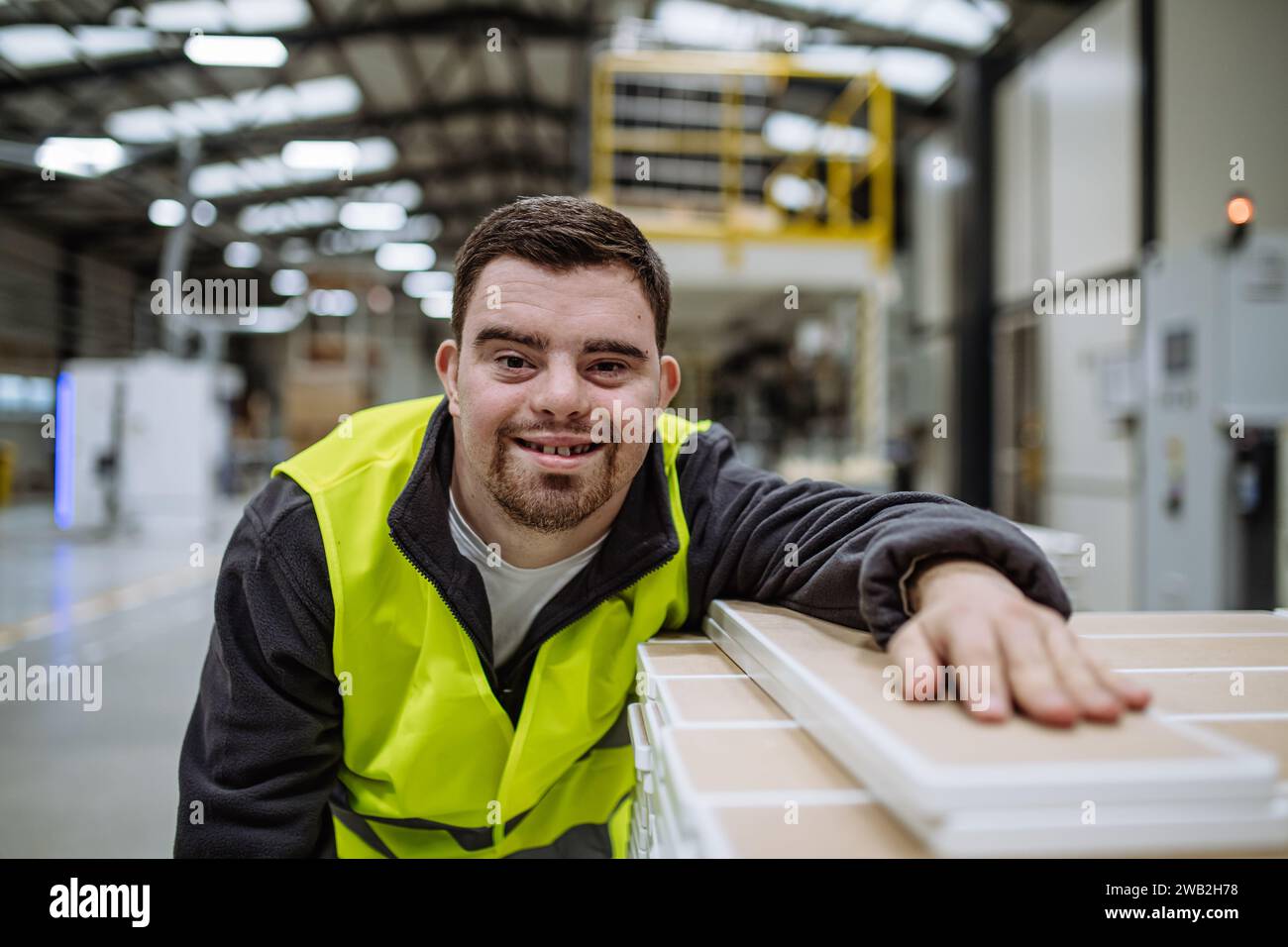 Portrait of young man with Down syndrome working in warehouse. Concept ...