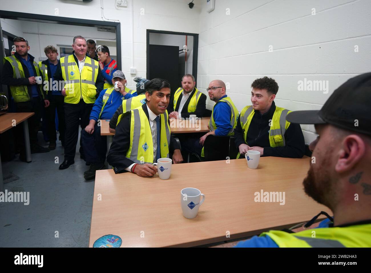 Prime Minister Rishi Sunak (centre) speaking to staff during a visit to ...