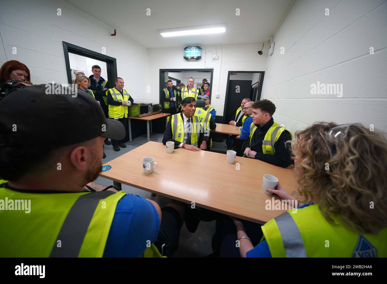 Prime Minister Rishi Sunak (centre) speaking to staff during a visit to ...