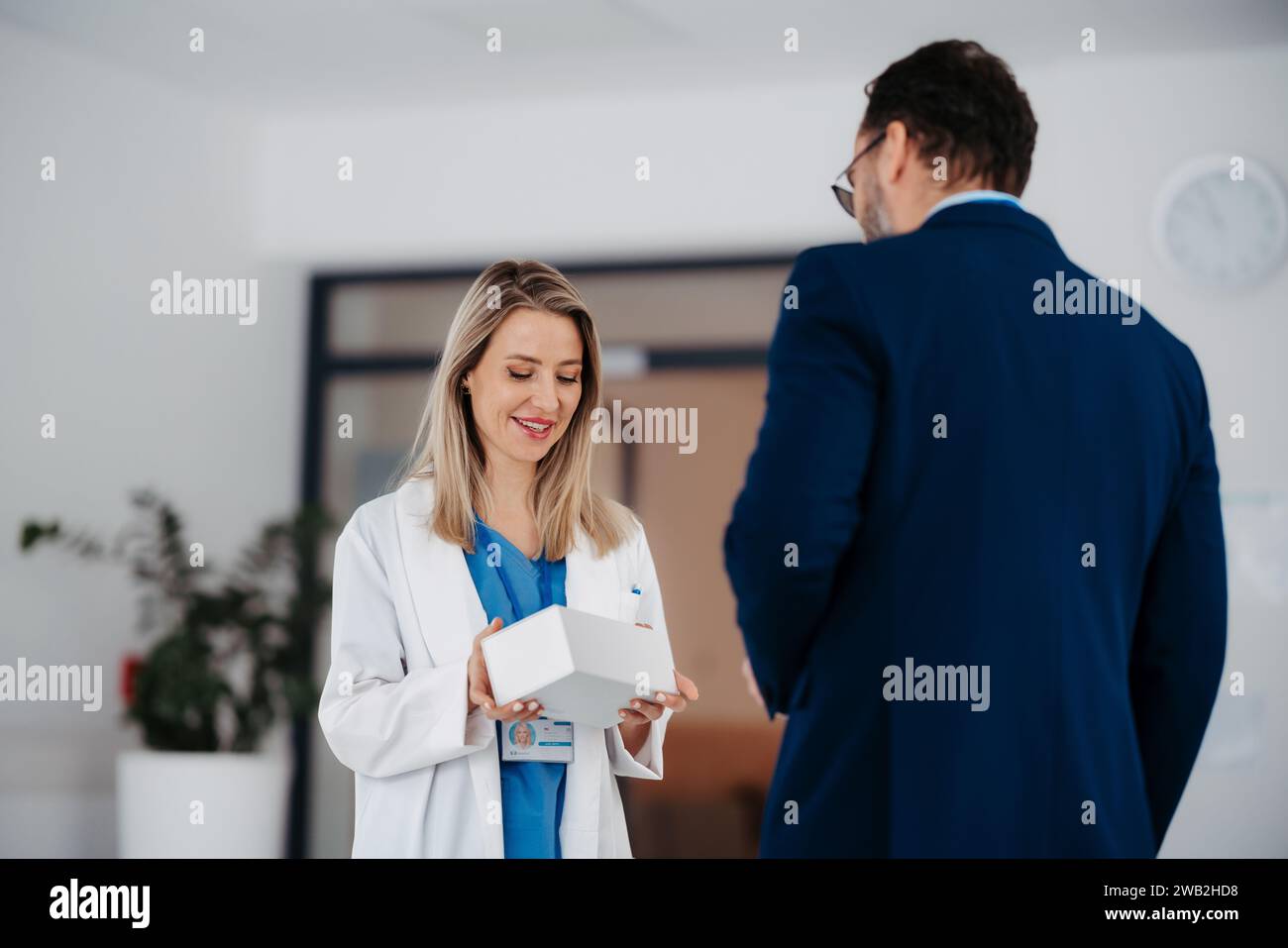 Pharmaceutical sales representative talking with female doctor in ...