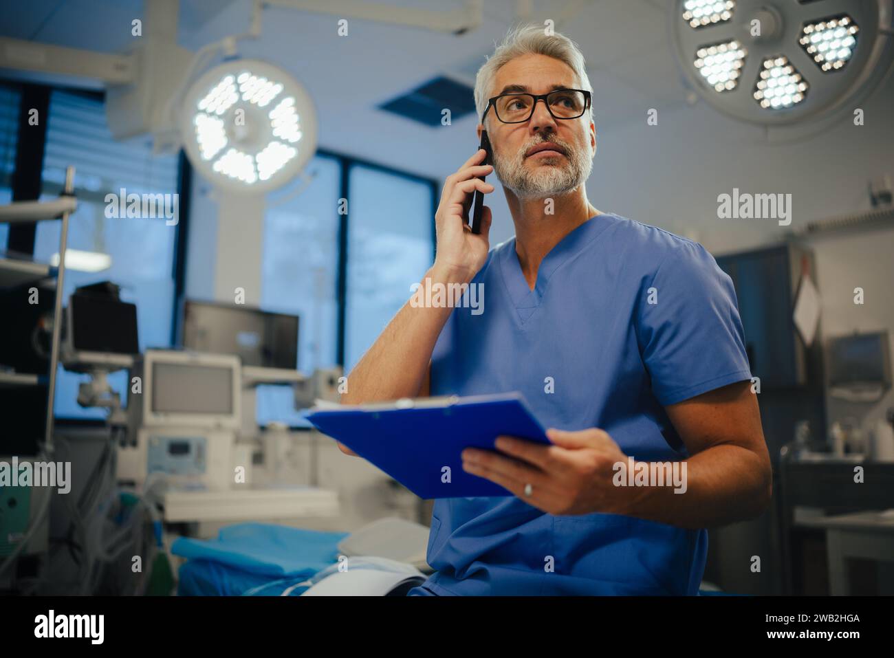 Portrait of confident ER doctor standing in hospital emergency room and ...