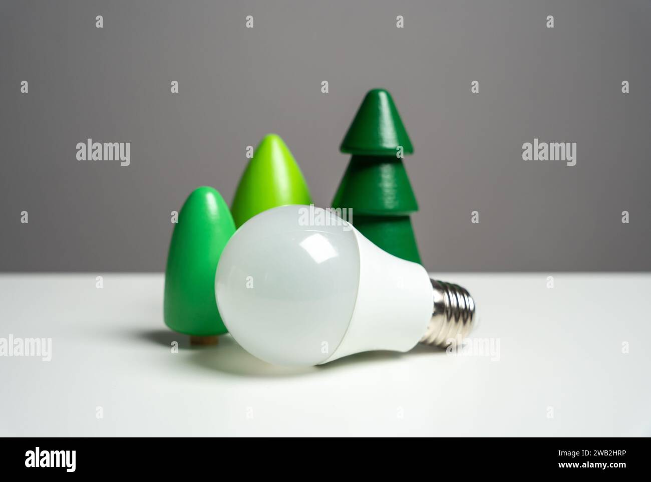Energy saving light bulb surrounded by forest trees. Harmonious blend ...