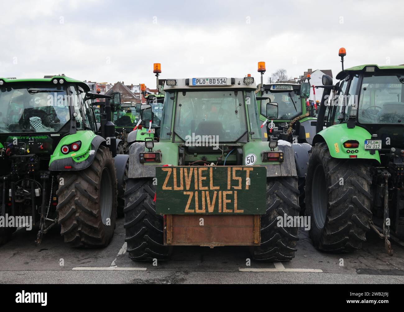 Kiel, Germany. 08th Jan, 2024. Farmers with their tractors stand at a ...
