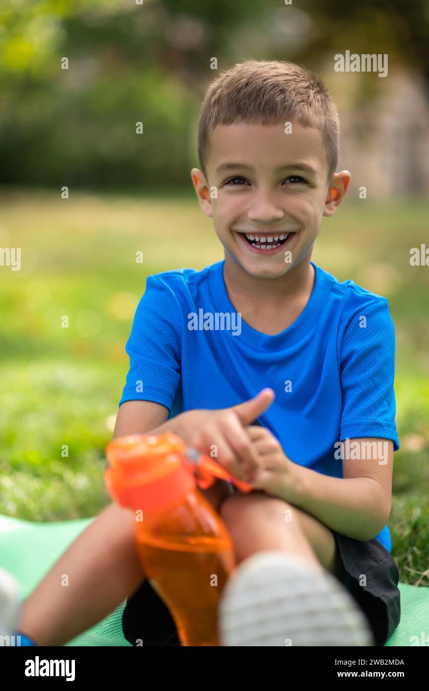 Cute boy of school age in blue tshirt looking contented Stock Photo - Alamy
