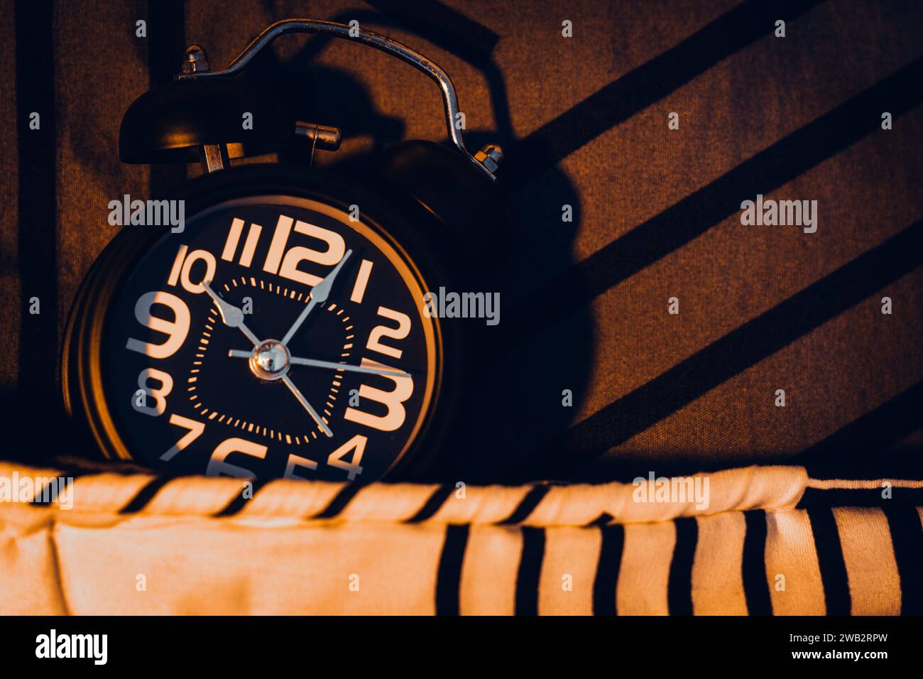 Black alarm clock on the bed. Time to sleep Stock Photo - Alamy