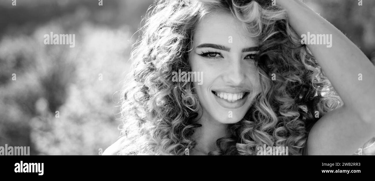 Spring girl with curly hair smiling. Beauty young woman enjoying nature ...