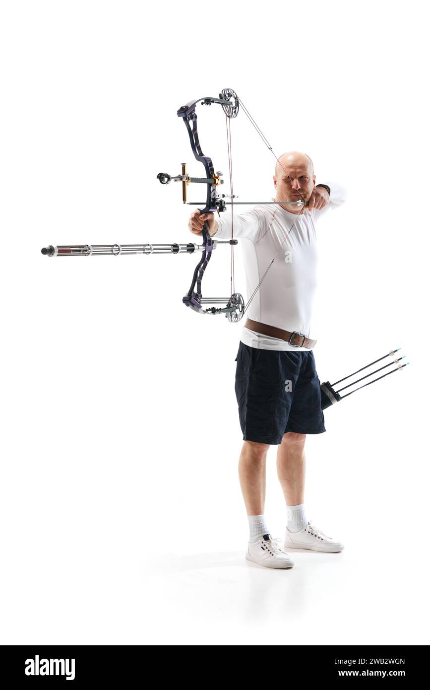 Full-length of serious man, archery sportsman aiming archery bow on ...