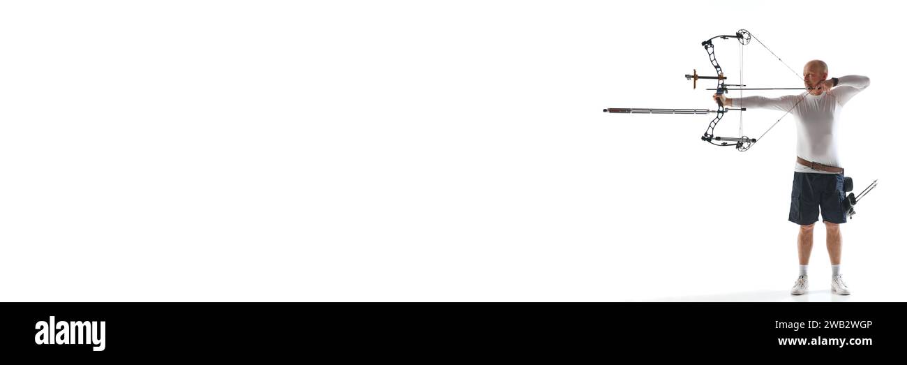 Concentrated man aiming archery bow, practicing isolated over white ...