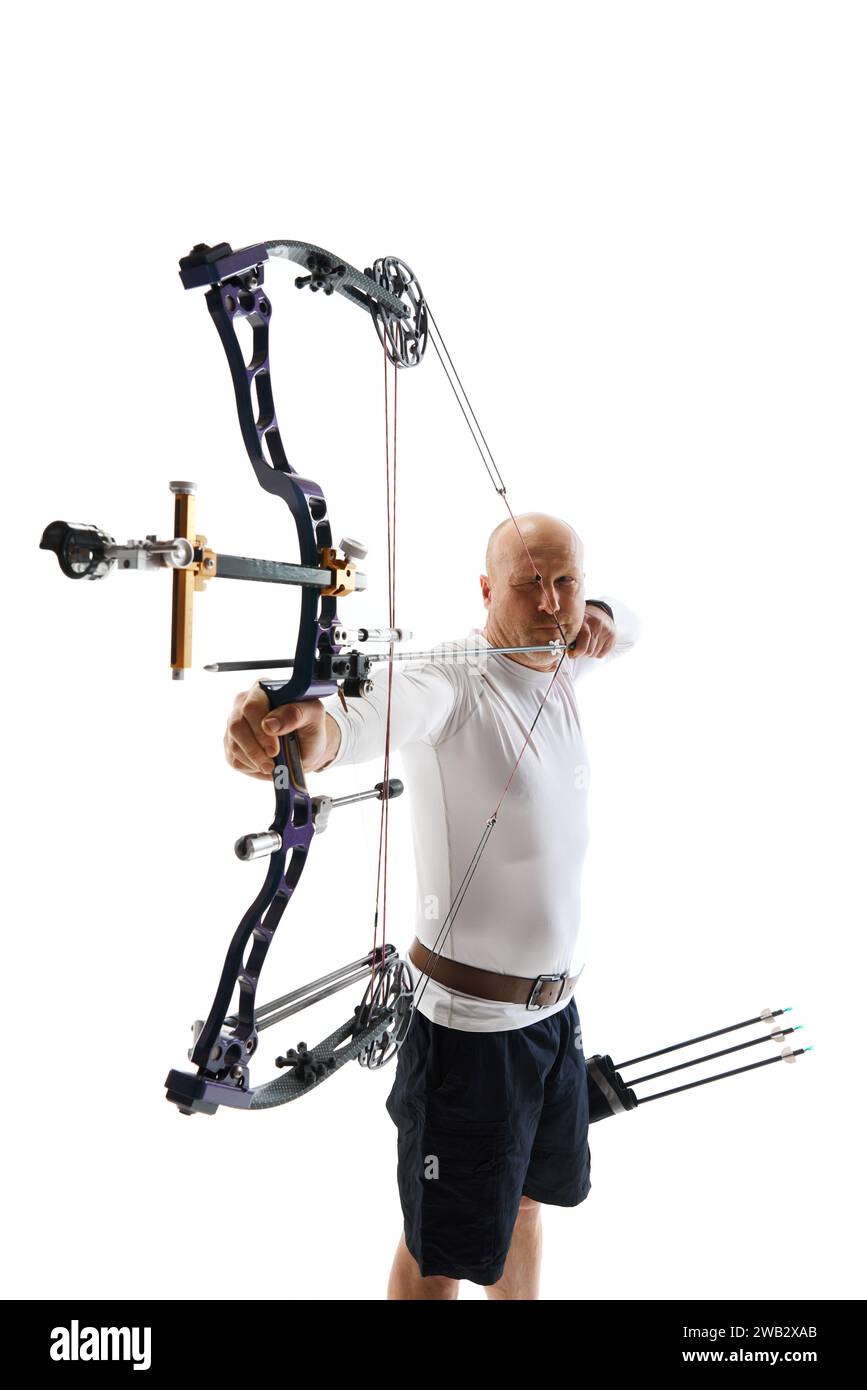 Man in his 40s, archery athlete with bow and arrow aiming at archery ...