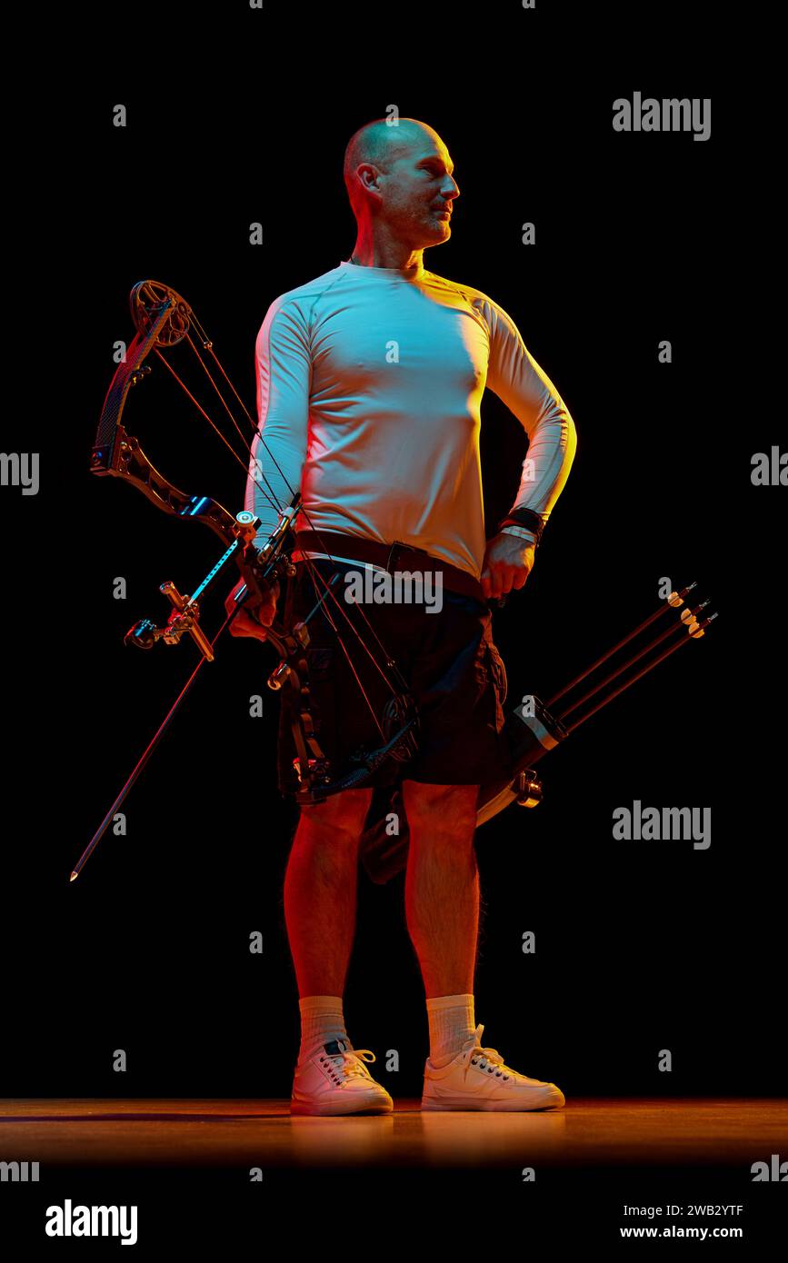 Full-length image of man, archer standing with archery bow and arrows ...