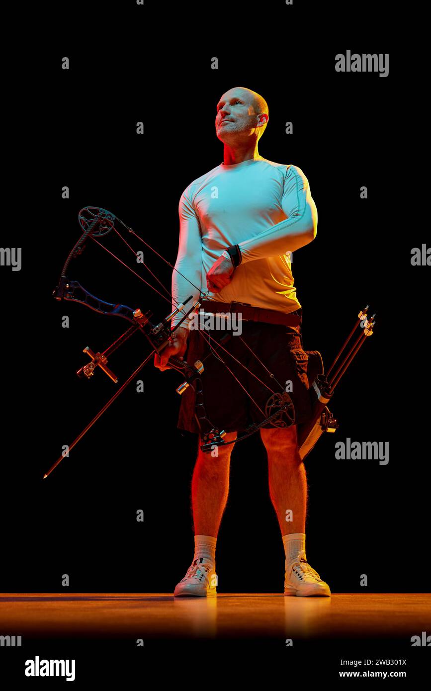 Full-length image of man, archer standing with archery bow and arrows ...