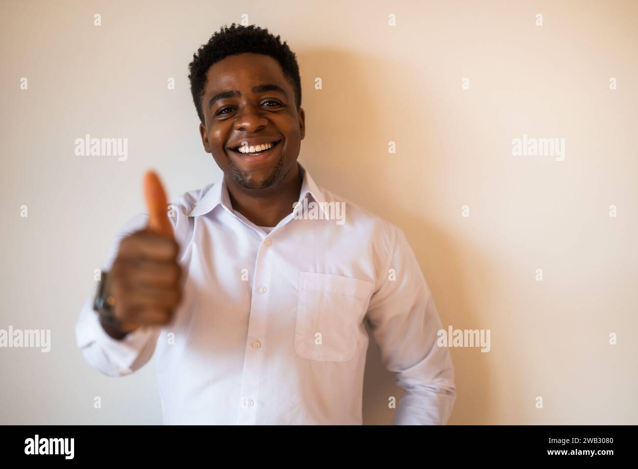 Portrait of happy man who is smiling and showing thumbs up. Copy space ...