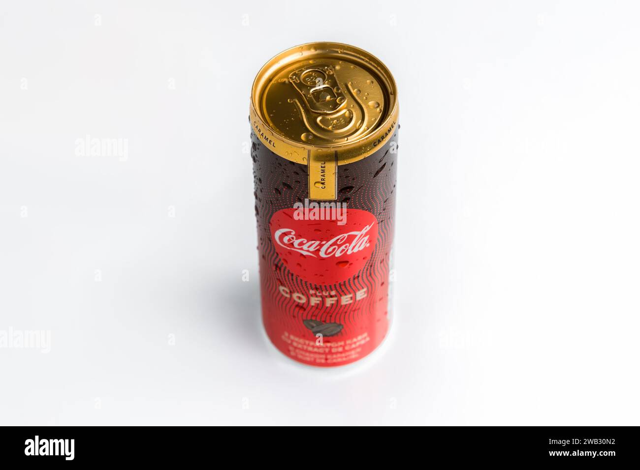 A can of Coca-Cola Plus Coffee Caramel with drops of water on a white ...