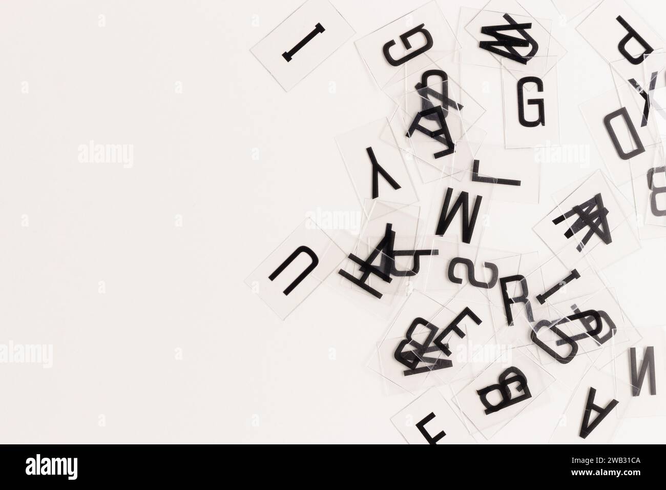 Transparent plastic cards with letters scattered on a gray background ...
