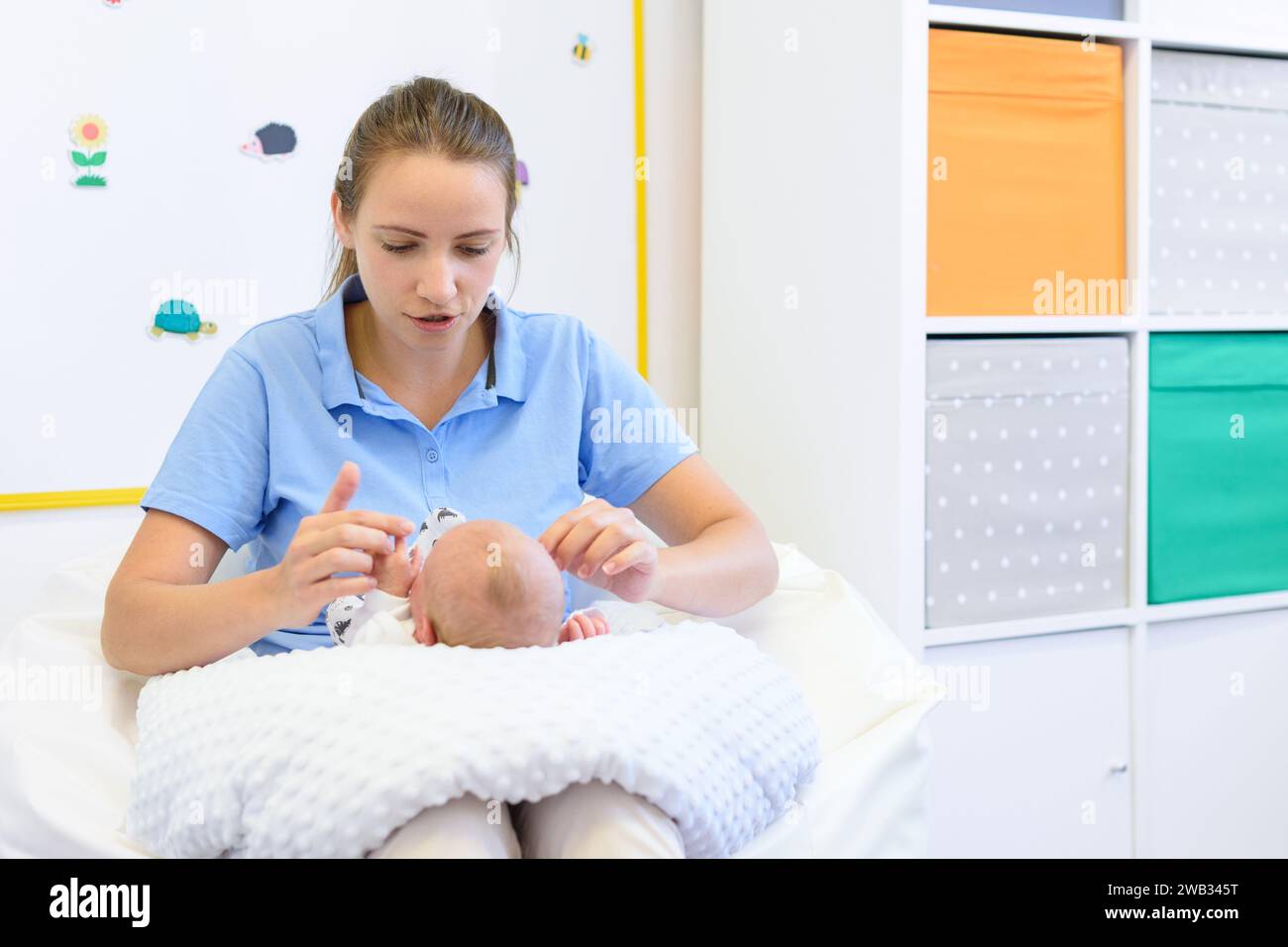 Mother comforting newborn. Midwife doing medical check on a newborn ...
