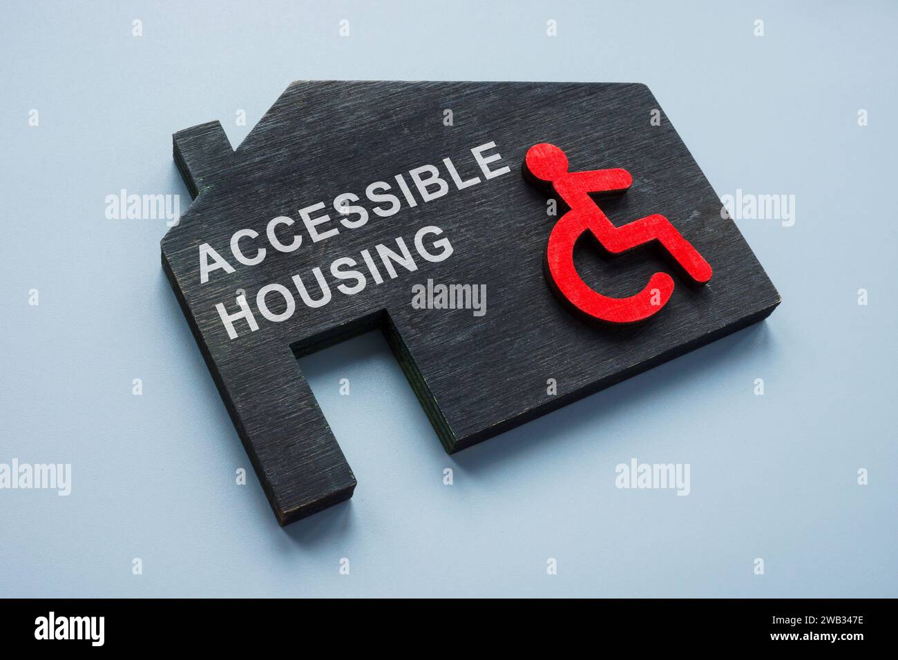 Accessible housing. Model of house and disabled person sign Stock Photo ...