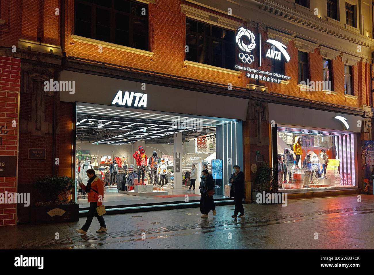 Customers pass an ANTA store on Nanjing Road Pedestrian street in ...