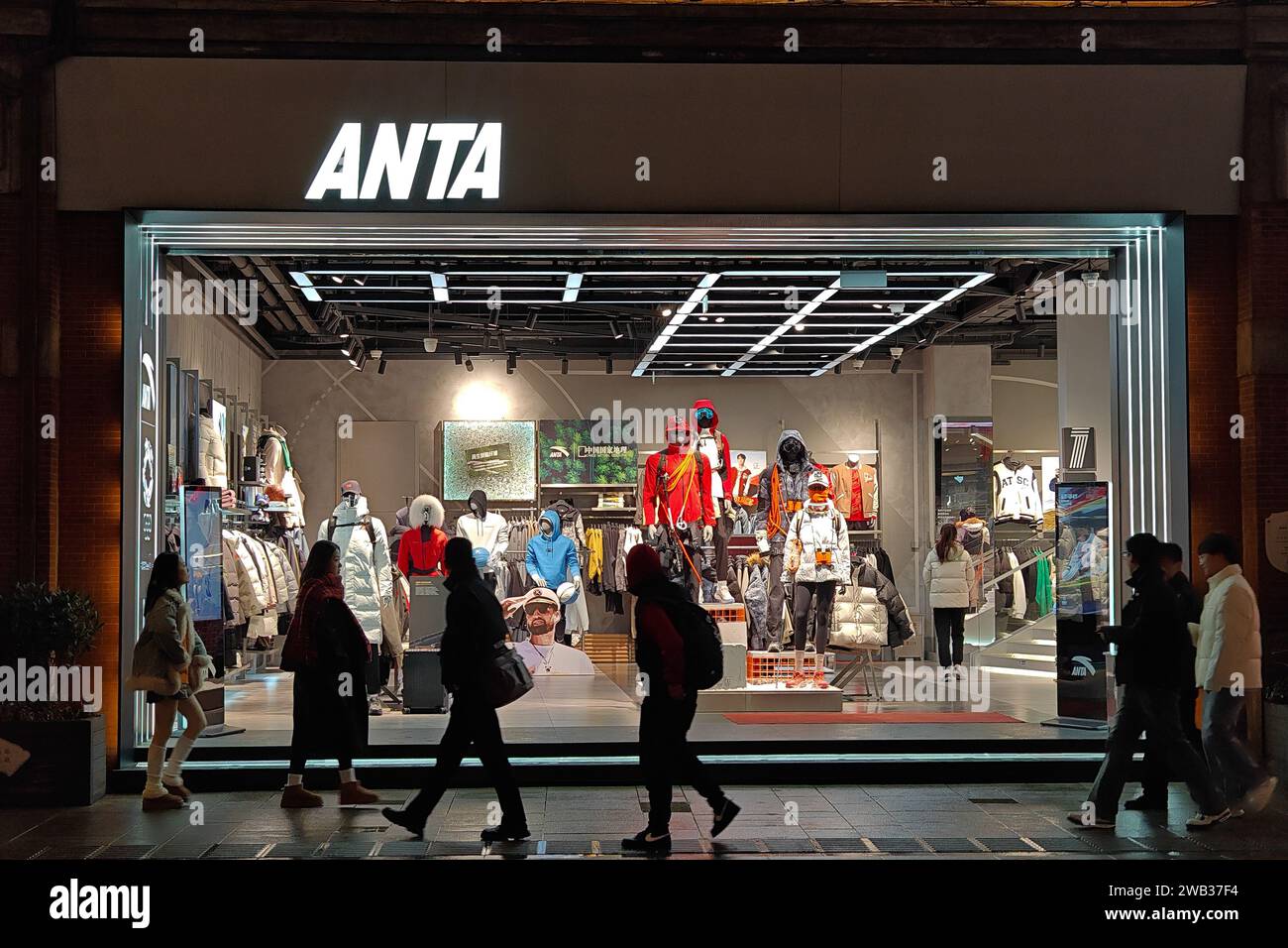 Customers pass an ANTA store on Nanjing Road Pedestrian street in ...