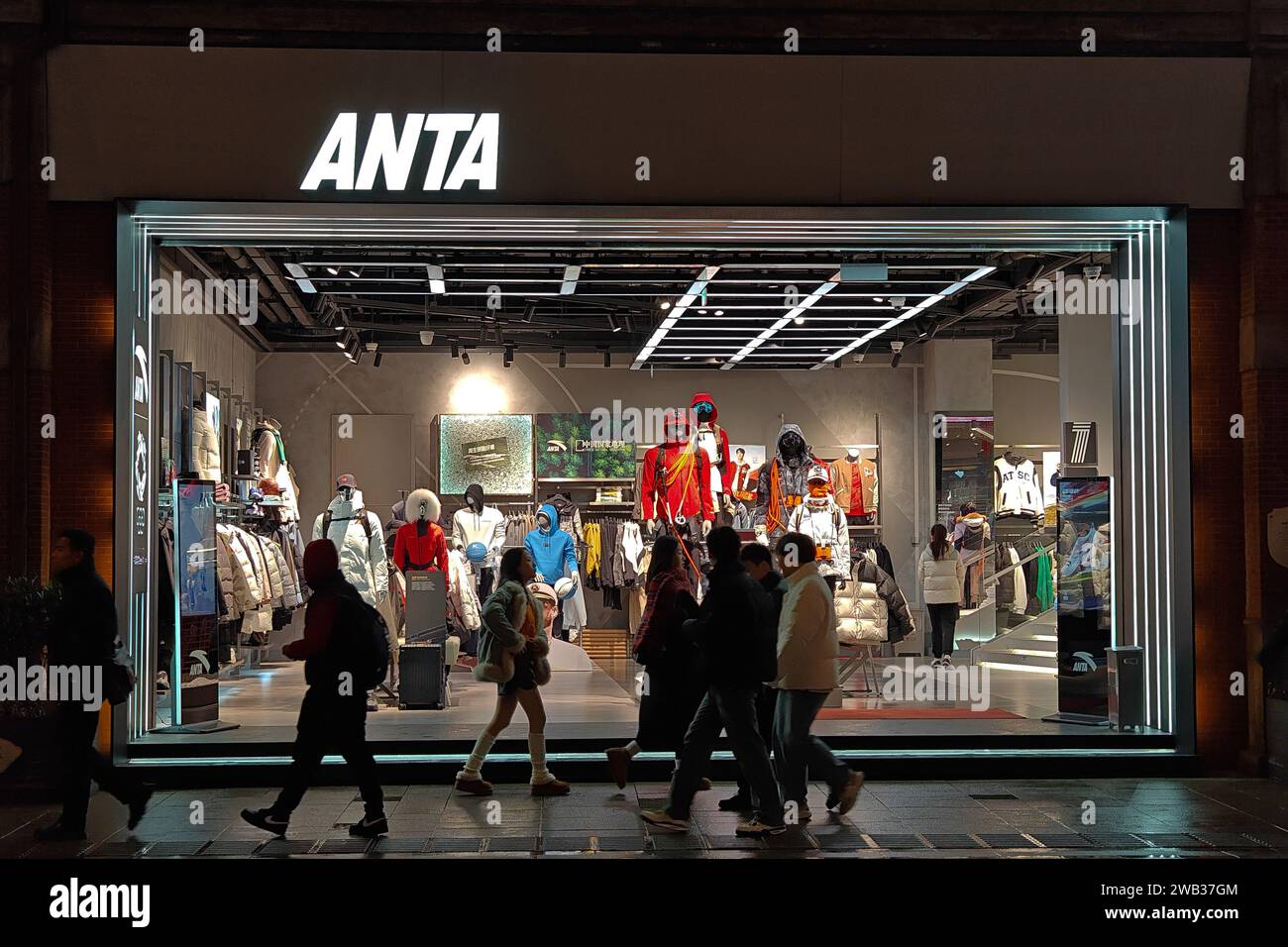Customers pass an ANTA store on Nanjing Road Pedestrian street in ...