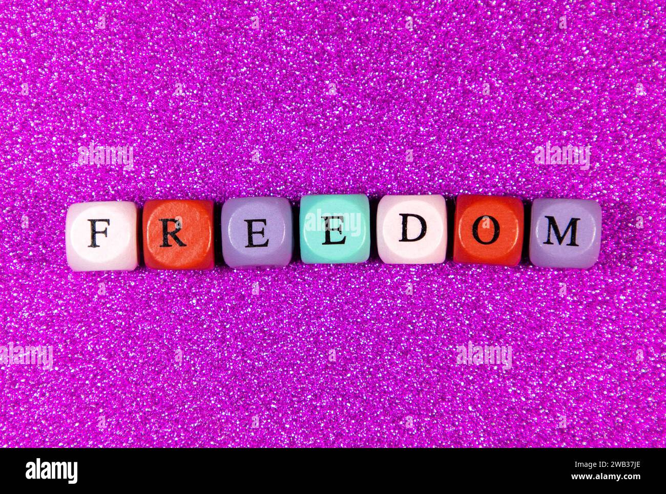 The word Freedom written with colorful cubic beads on a purple ...