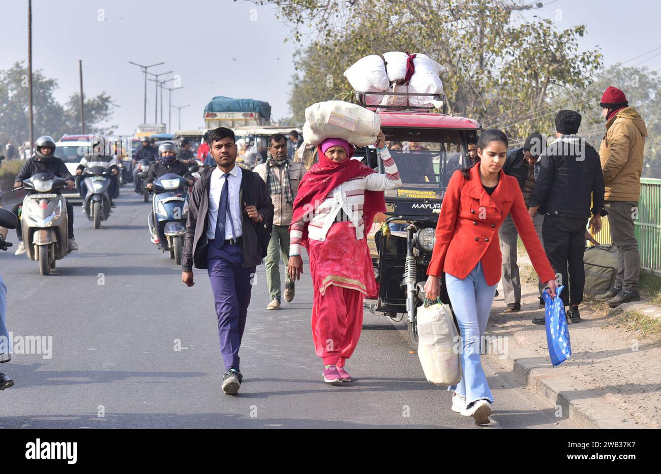 GHAZIABAD, INDIA - JANUARY 2: People walking on foot as buses and autos ...