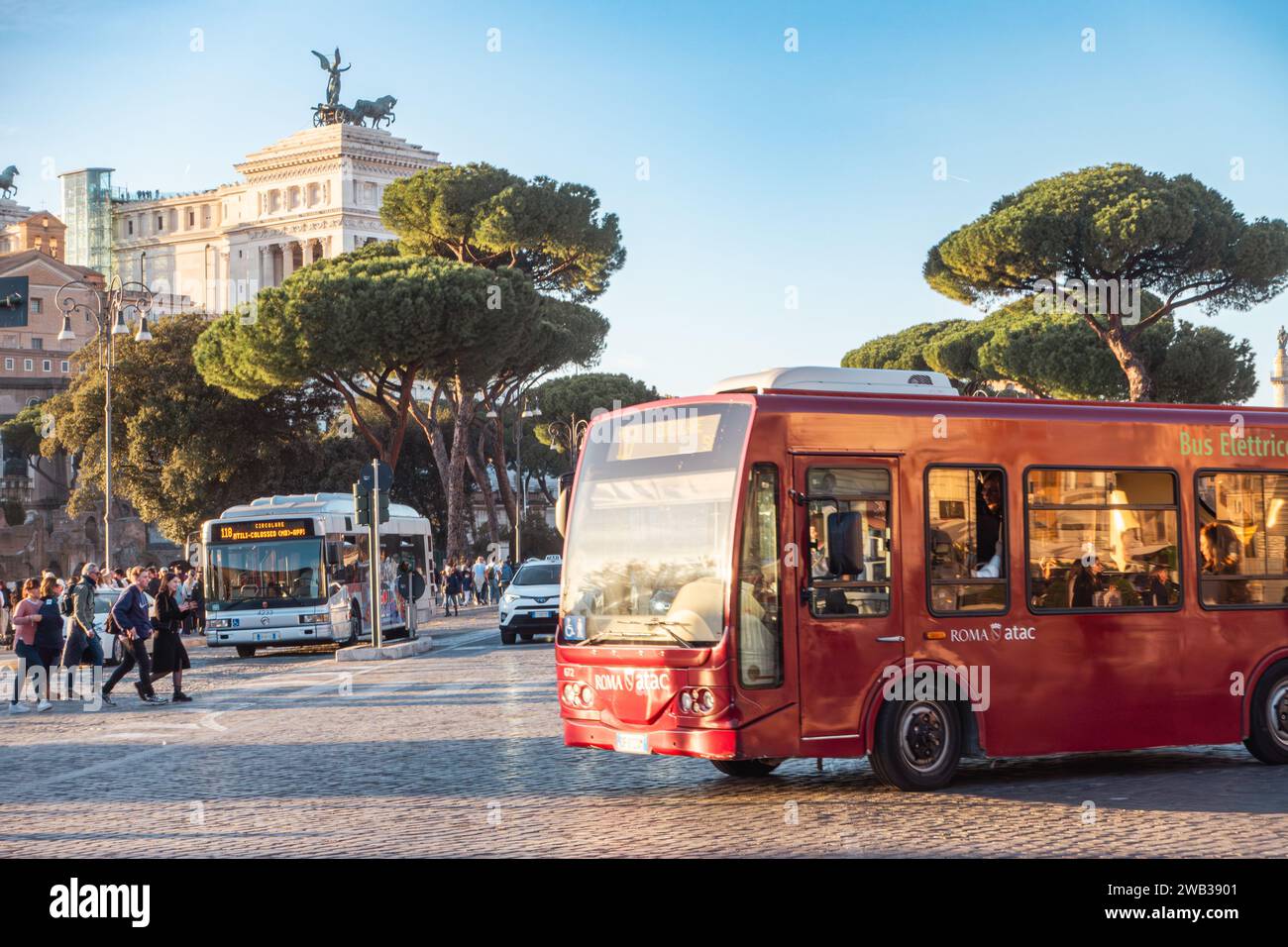 Rome, public transport. Street with buses, tourists and monuments in ...