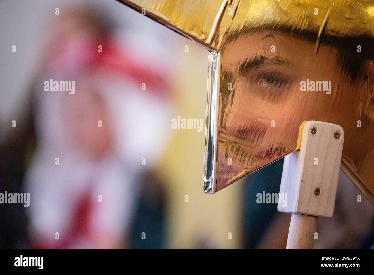 Stuttgart, Germany. 08th Jan, 2024. A carol singer is reflected in a ...