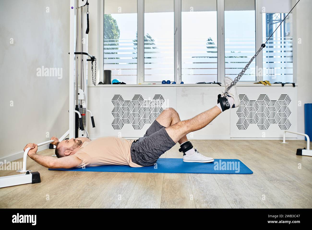 side view of sportive man lying down on fitness mat during recovery ...
