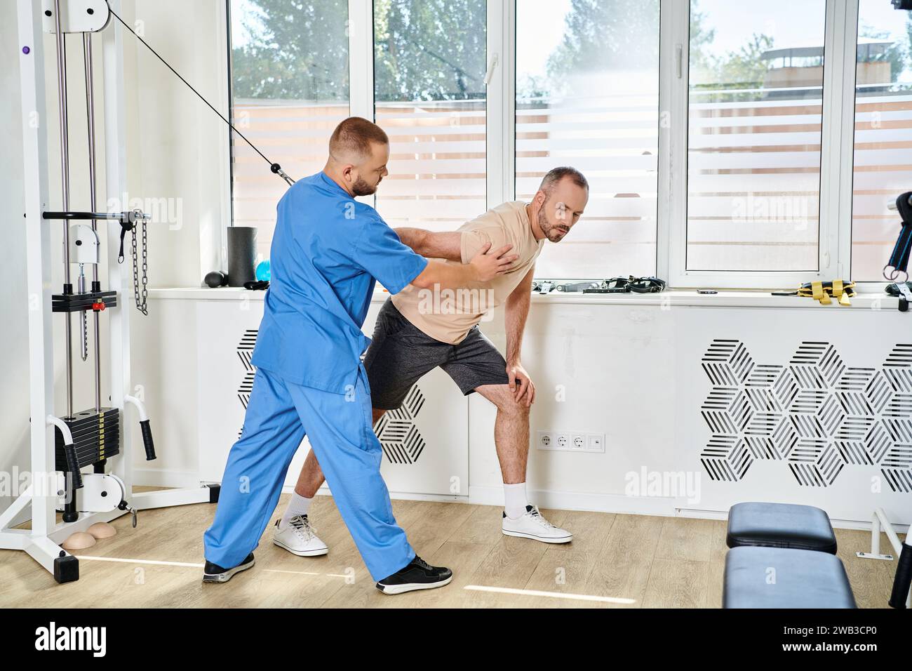 Instructor helping recovery exercise hi-res stock photography and ...