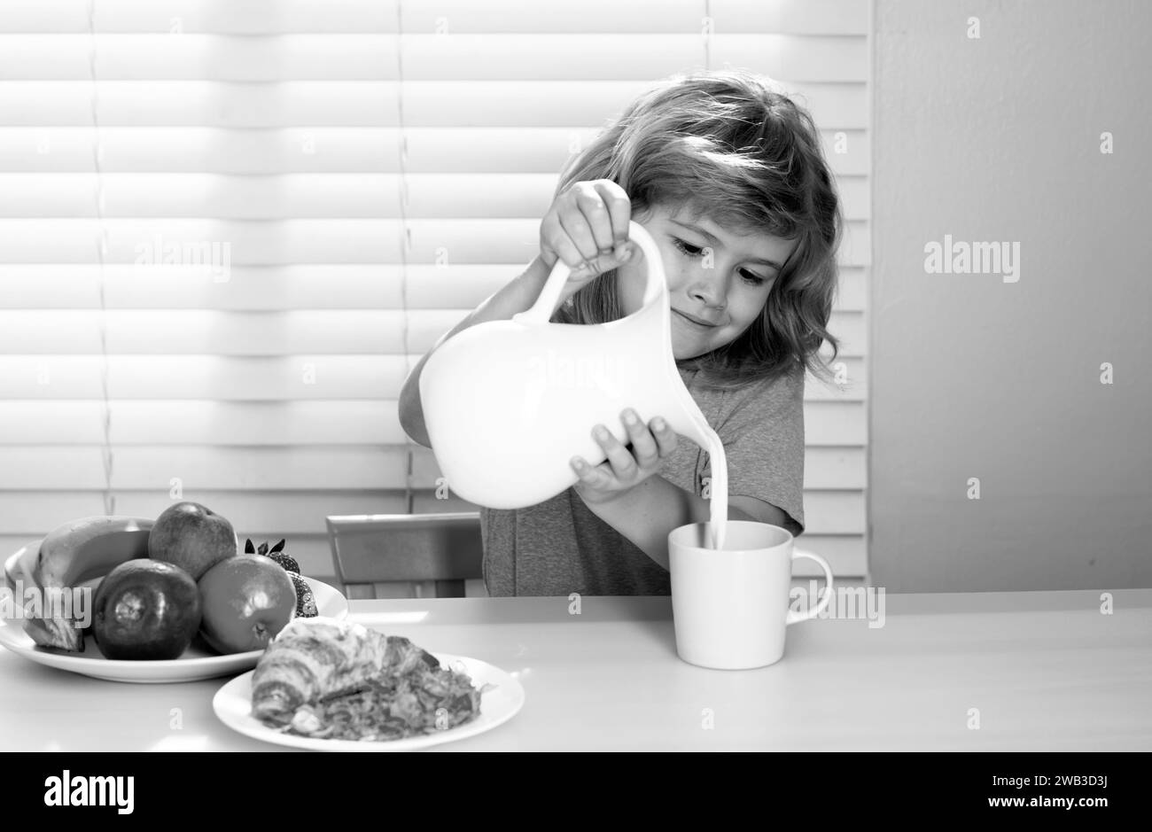 Fuuny little boy pouring whole cows milk for breakfast. Schoolkid ...
