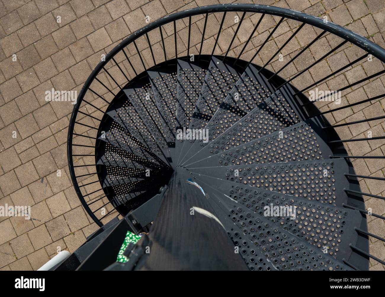 A top view of a metallic spiral staircase at a park after the rain ...