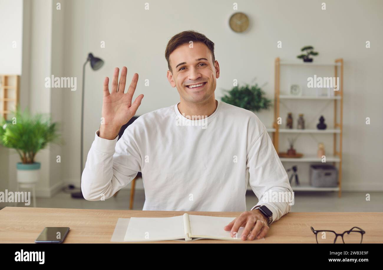 Man Waving Hi During Webcam Video Call in Home Office Stock Photo - Alamy