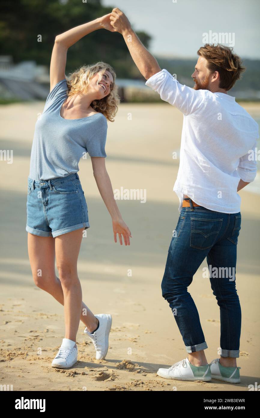 carefree young couple dance on the beach Stock Photo - Alamy