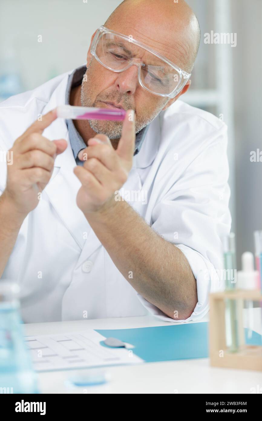 senior lab man pouring fluids Stock Photo - Alamy