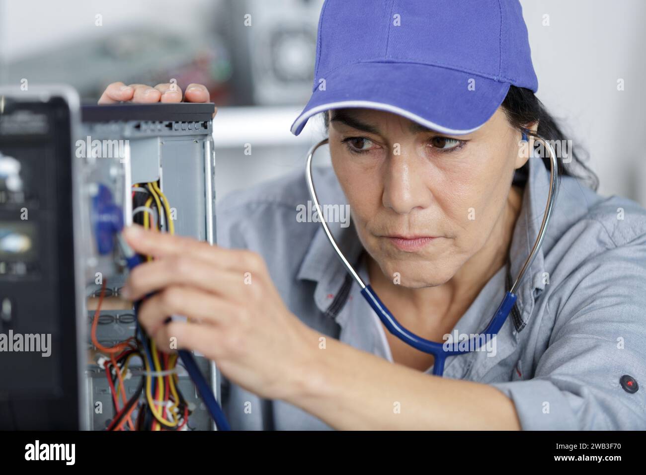 woman repairing computer turning to speak to customer Stock Photo - Alamy