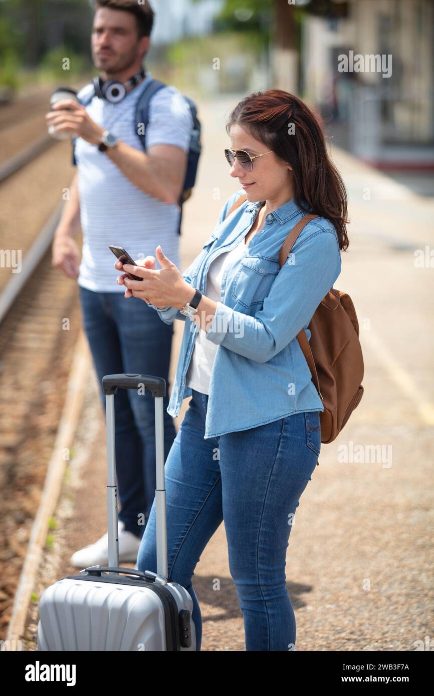 group of friends waiting the train in the platform Stock Photo - Alamy