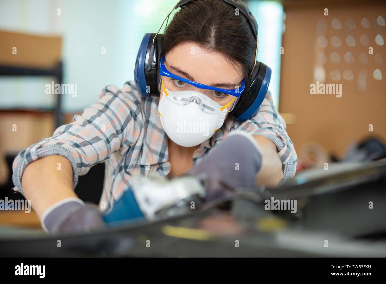 female worker using angle grinder and wearing a mask Stock Photo - Alamy