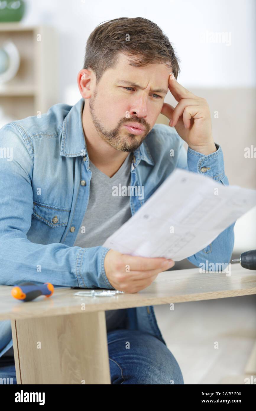 concentrated man does understand furniture Stock Photo - Alamy