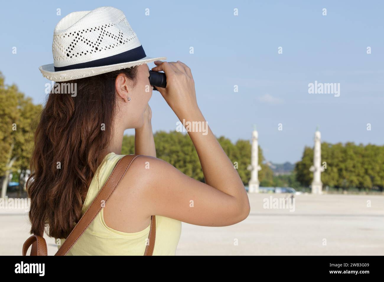 rear view of female tourist looking through compact binoculars Stock ...