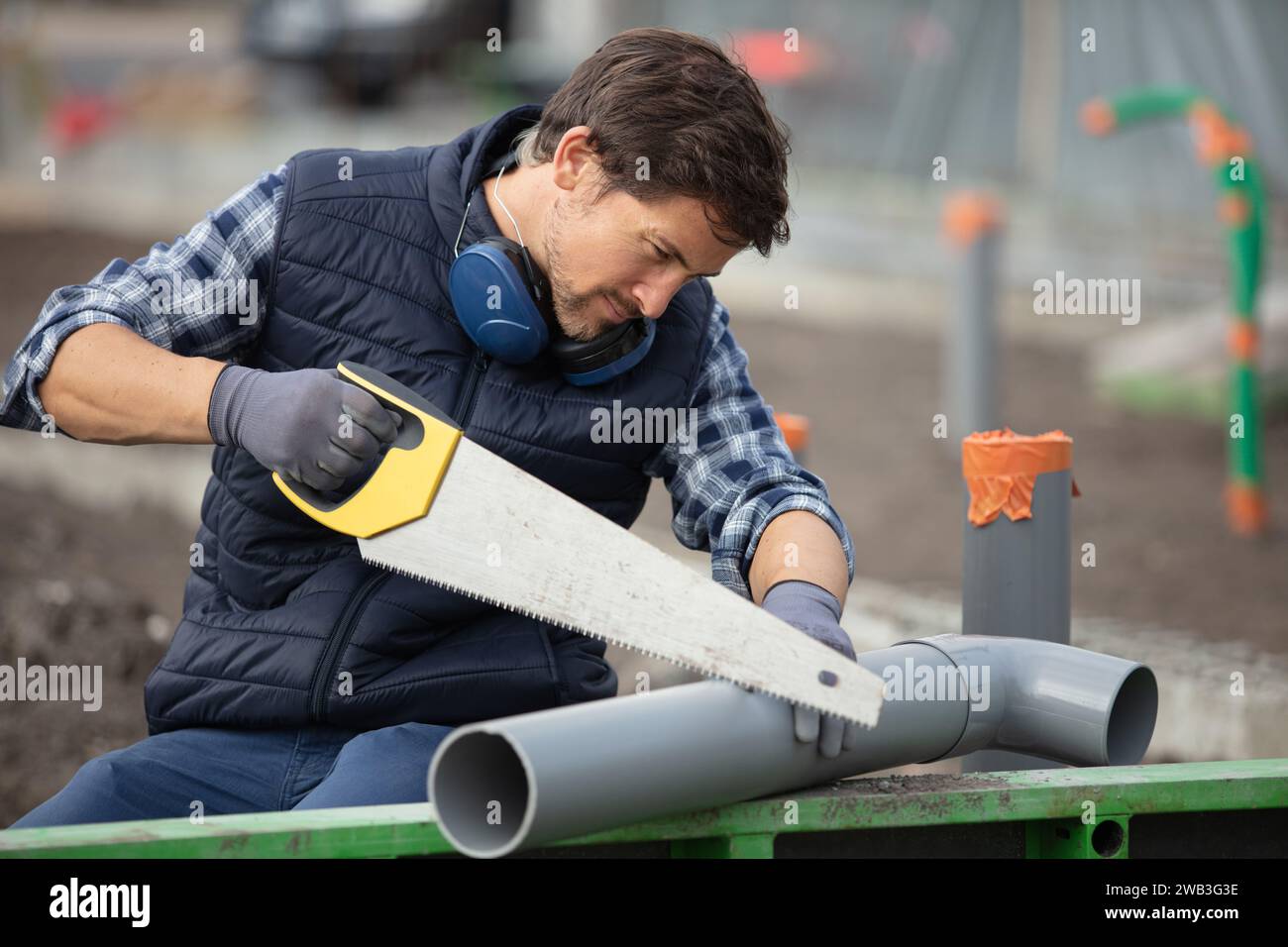 plumber cutting pvc pipe in the house construction Stock Photo - Alamy