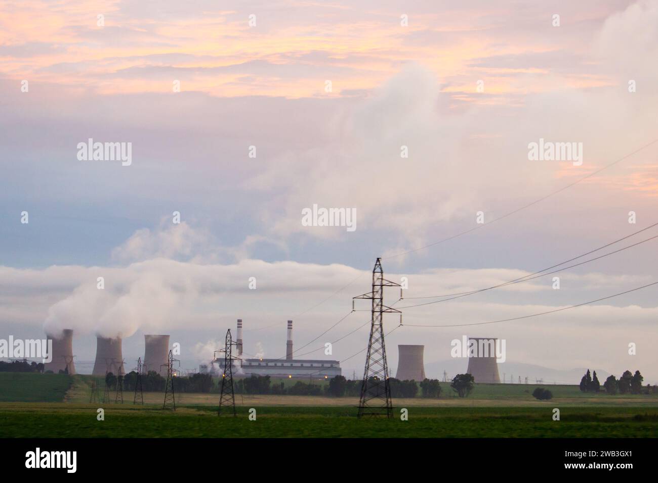 Power lines leading away from a coal fired power station at dawn in ...