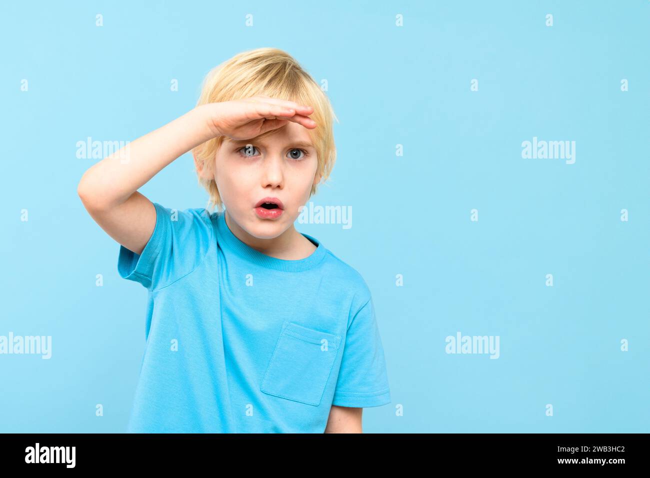 Cute preschooler looking curiously into distance with hand on the ...