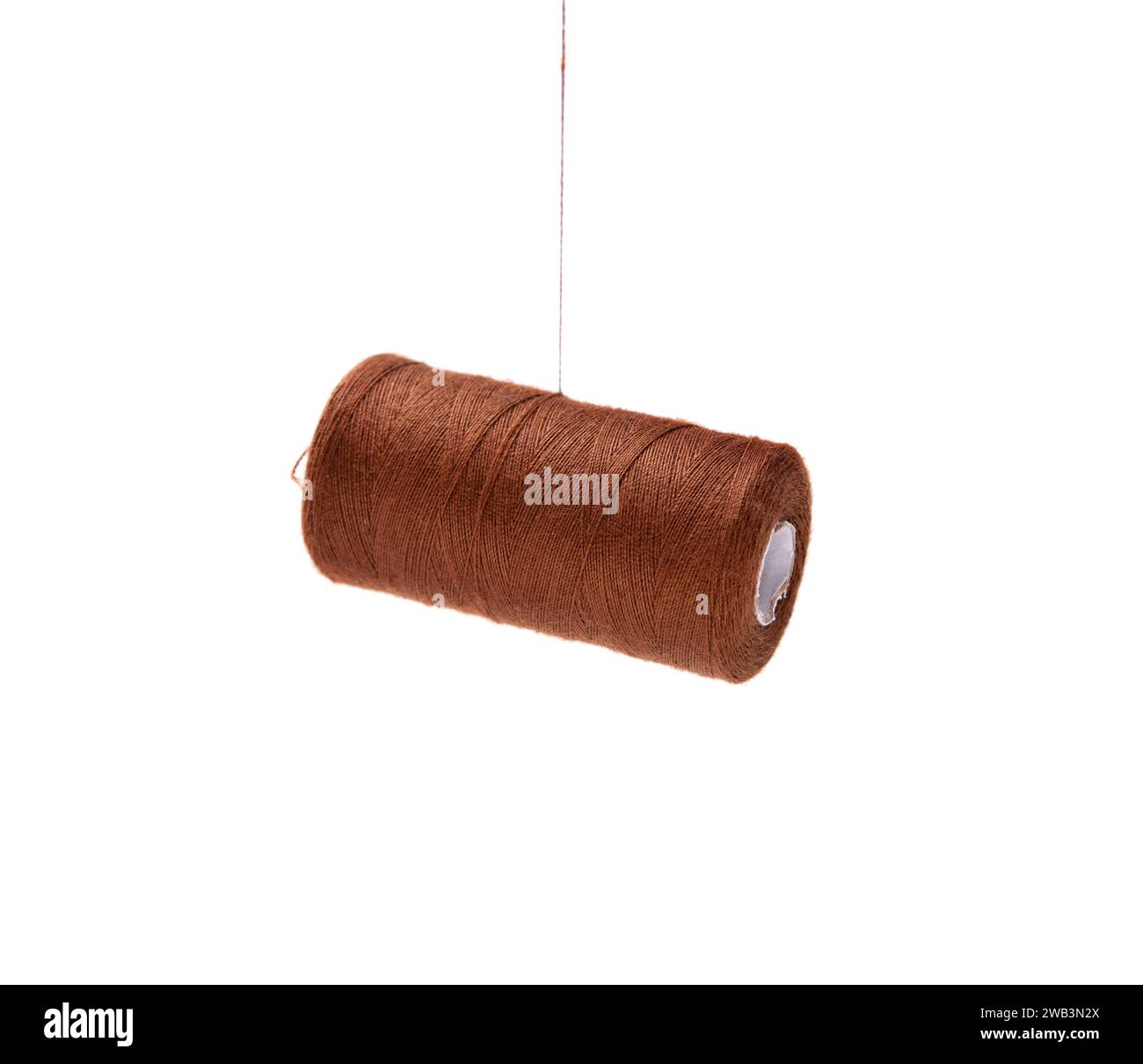 spools of brown color sewing cotton floating Stock Photo - Alamy