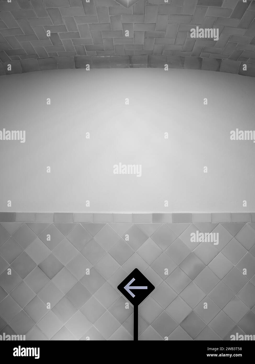 Left showing directional arrow sign on the wall in the underground ...