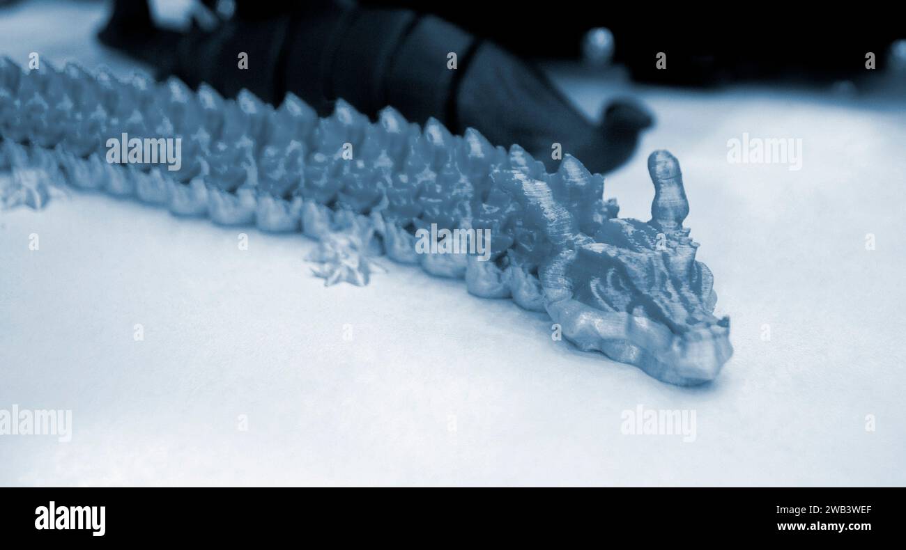 Prototype of blue dragon 3D printed from melted plastic. Close-up model ...