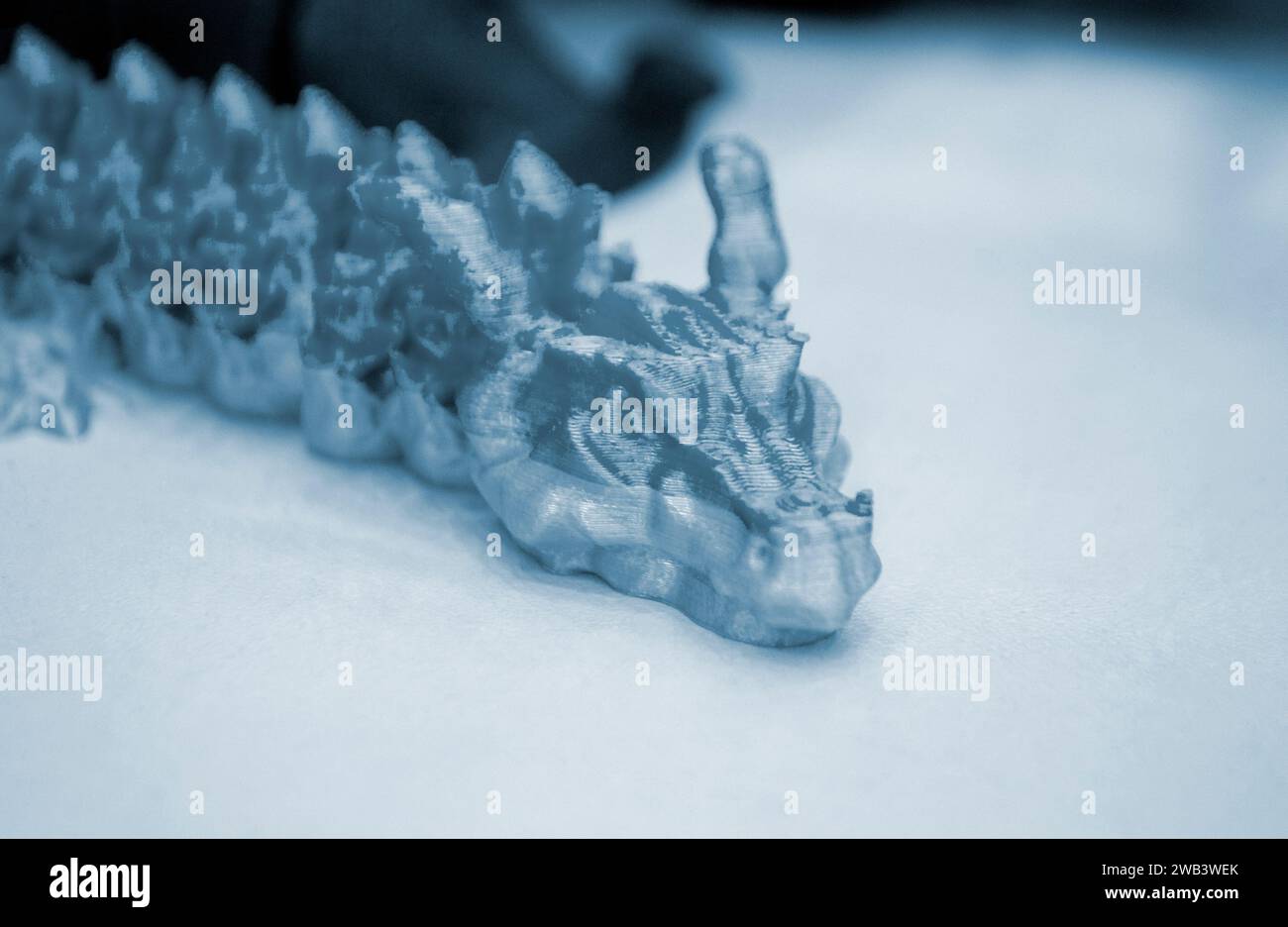 Prototype of blue dragon 3D printed from melted plastic. Close-up model ...