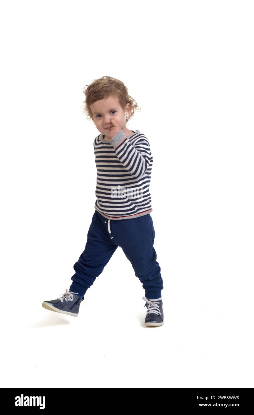 viw of a baby boy walking and scratch your face on white background ...
