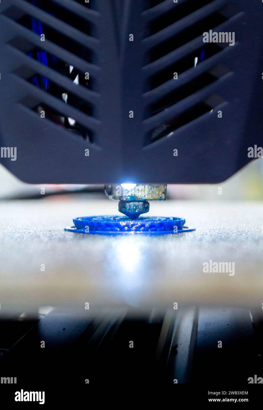 Working 3D printer printing object from blue plastic. Printing model ...
