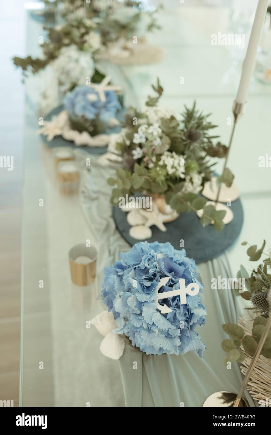 An exquisitely-set table featuring a vibrant display of blue flowers ...