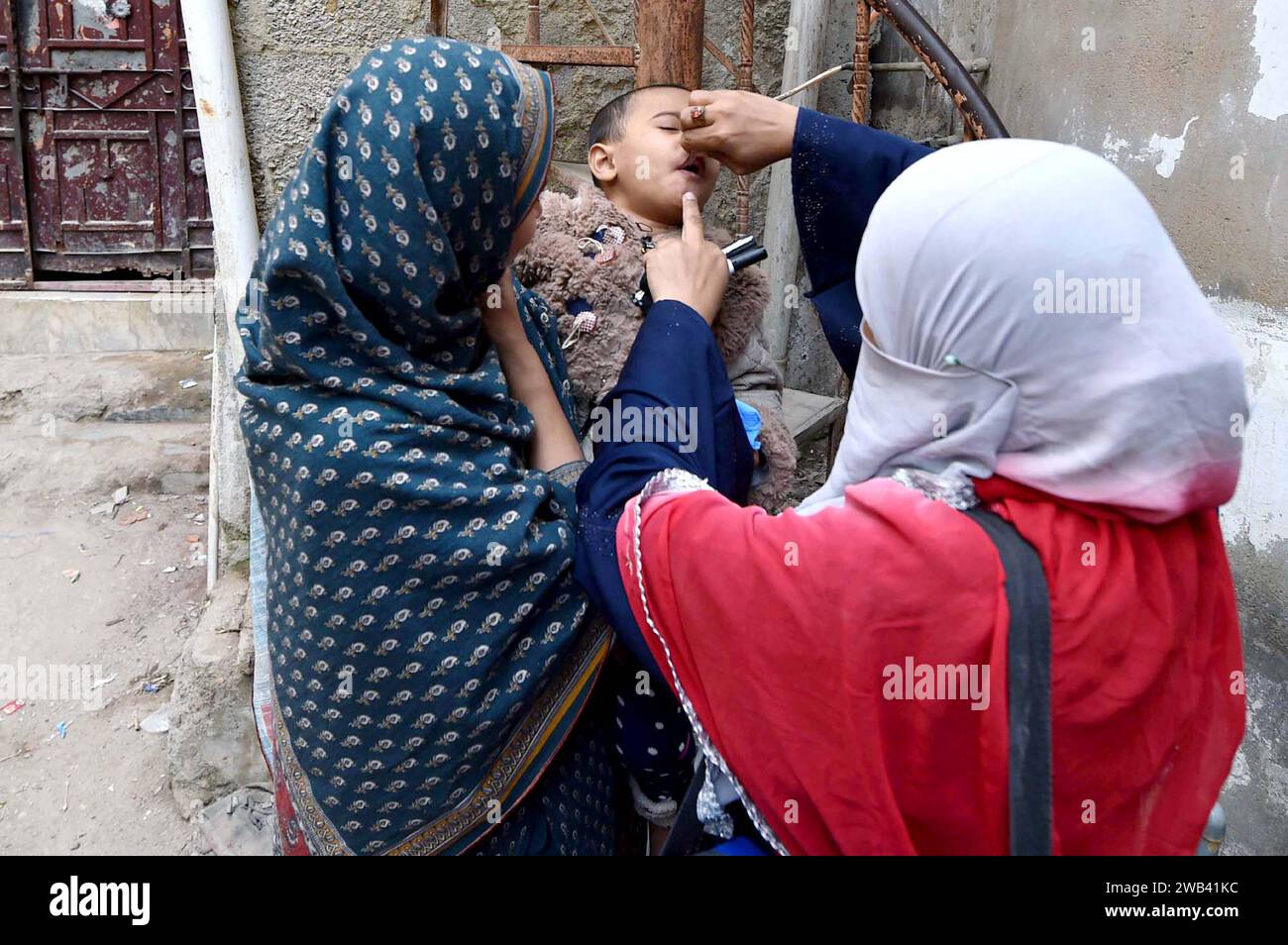 Health worker administrates polio-vaccine drops to a child during anti ...
